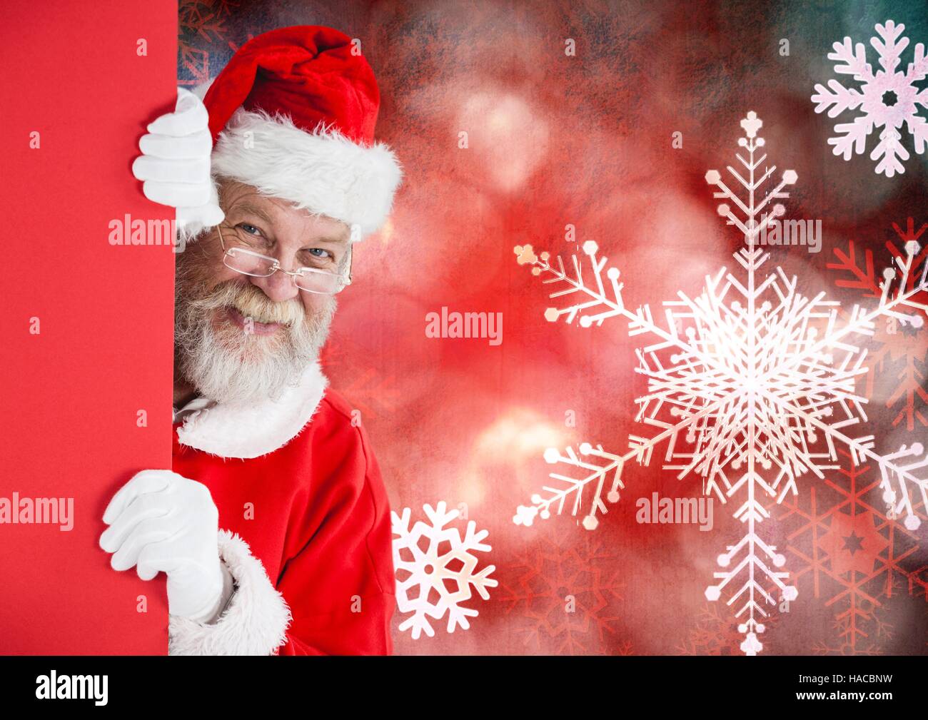 Santa claus peeking from red wall Stock Photo - Alamy