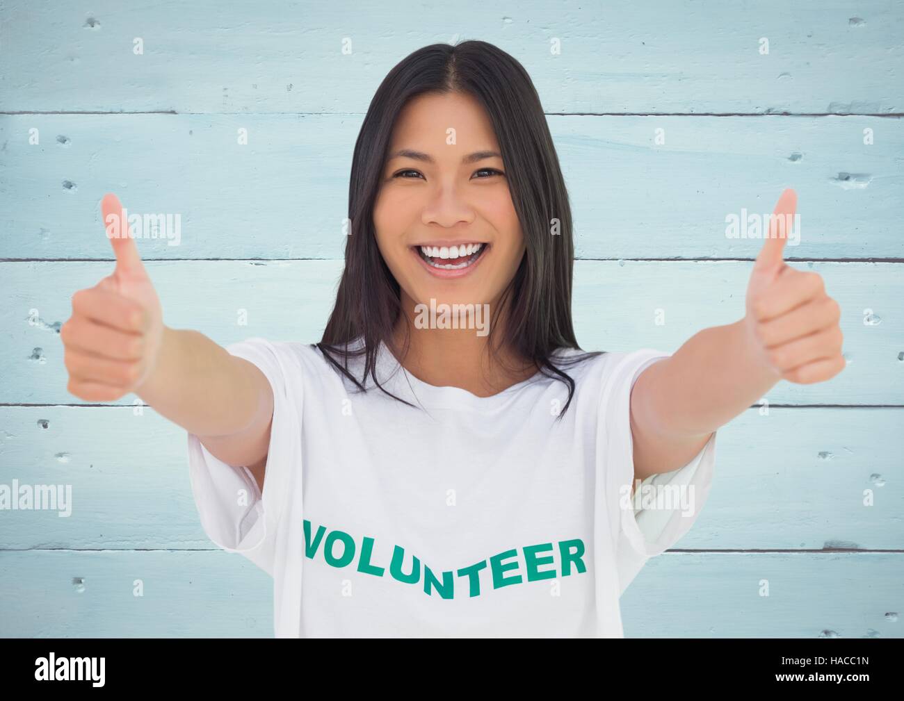 Smiling female volunteer showing thumbs up Stock Photo - Alamy