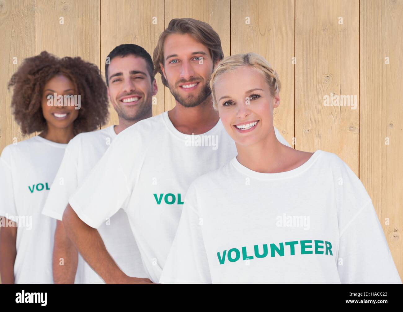 Group of volunteers standing against wooden background Stock Photo - Alamy