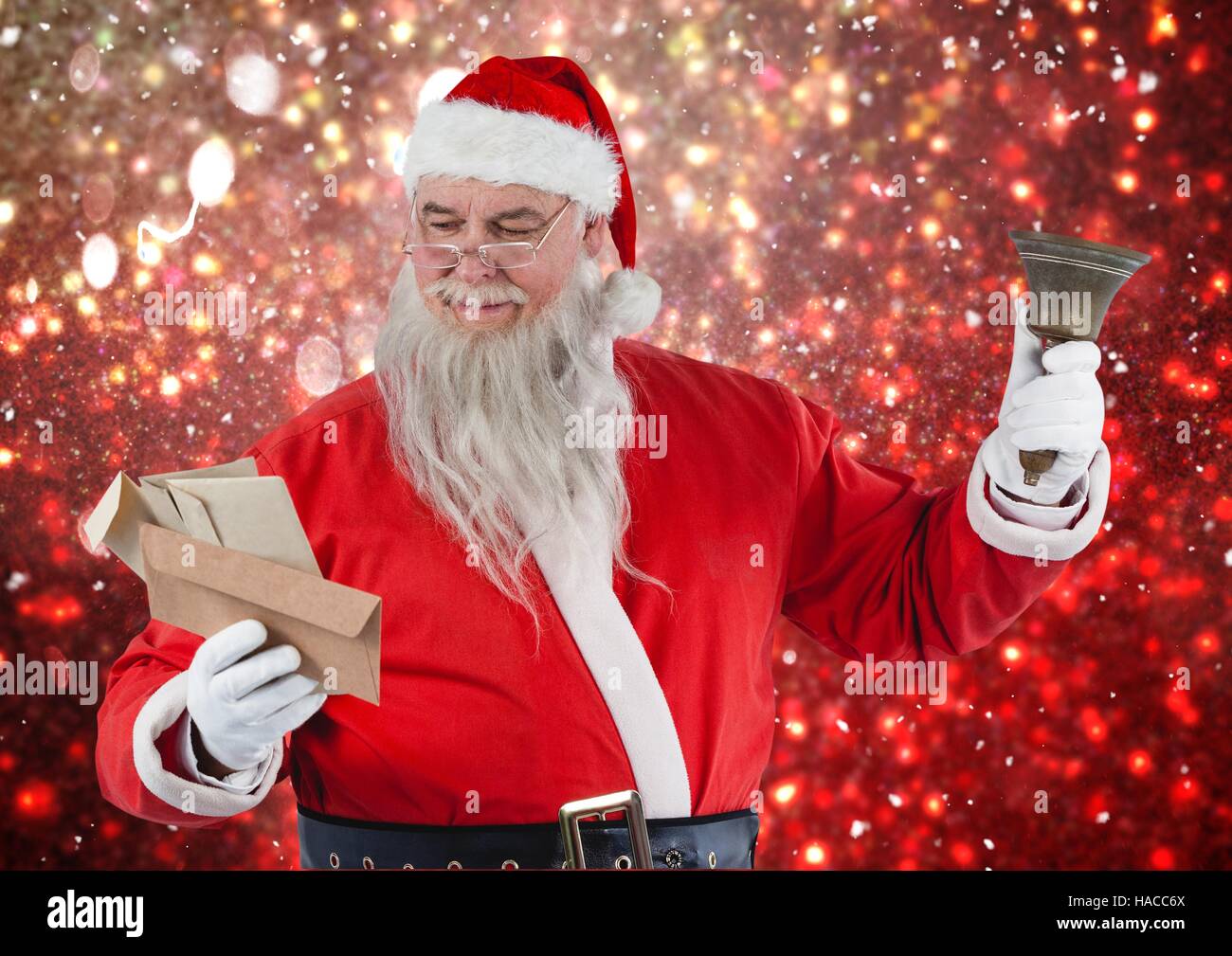 Santa holding bell and reading christmas letters Stock Photo - Alamy