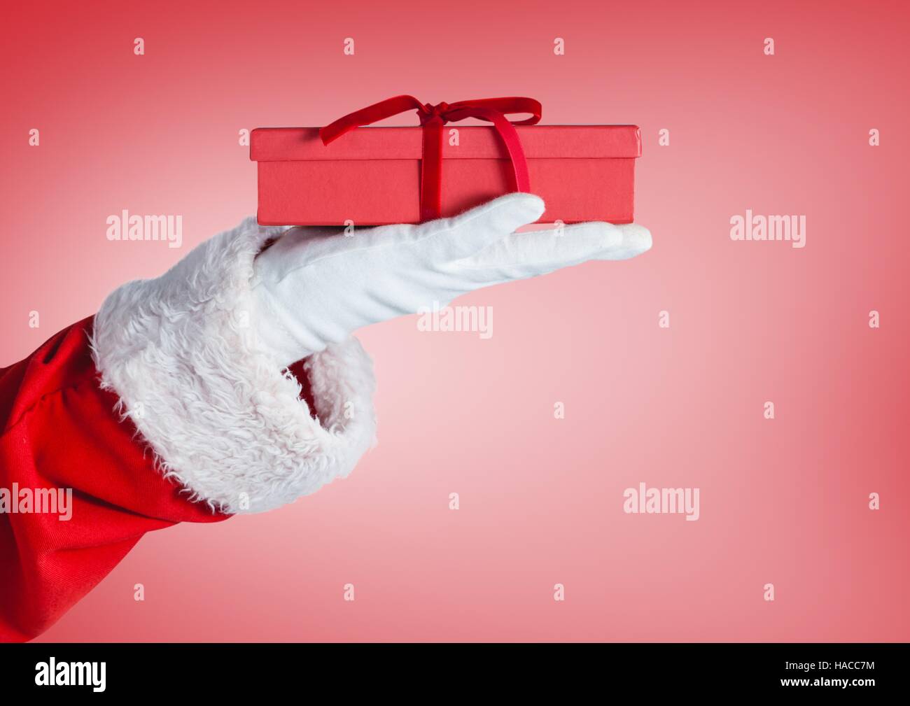 Santa claus holding a christmas gift Stock Photo - Alamy