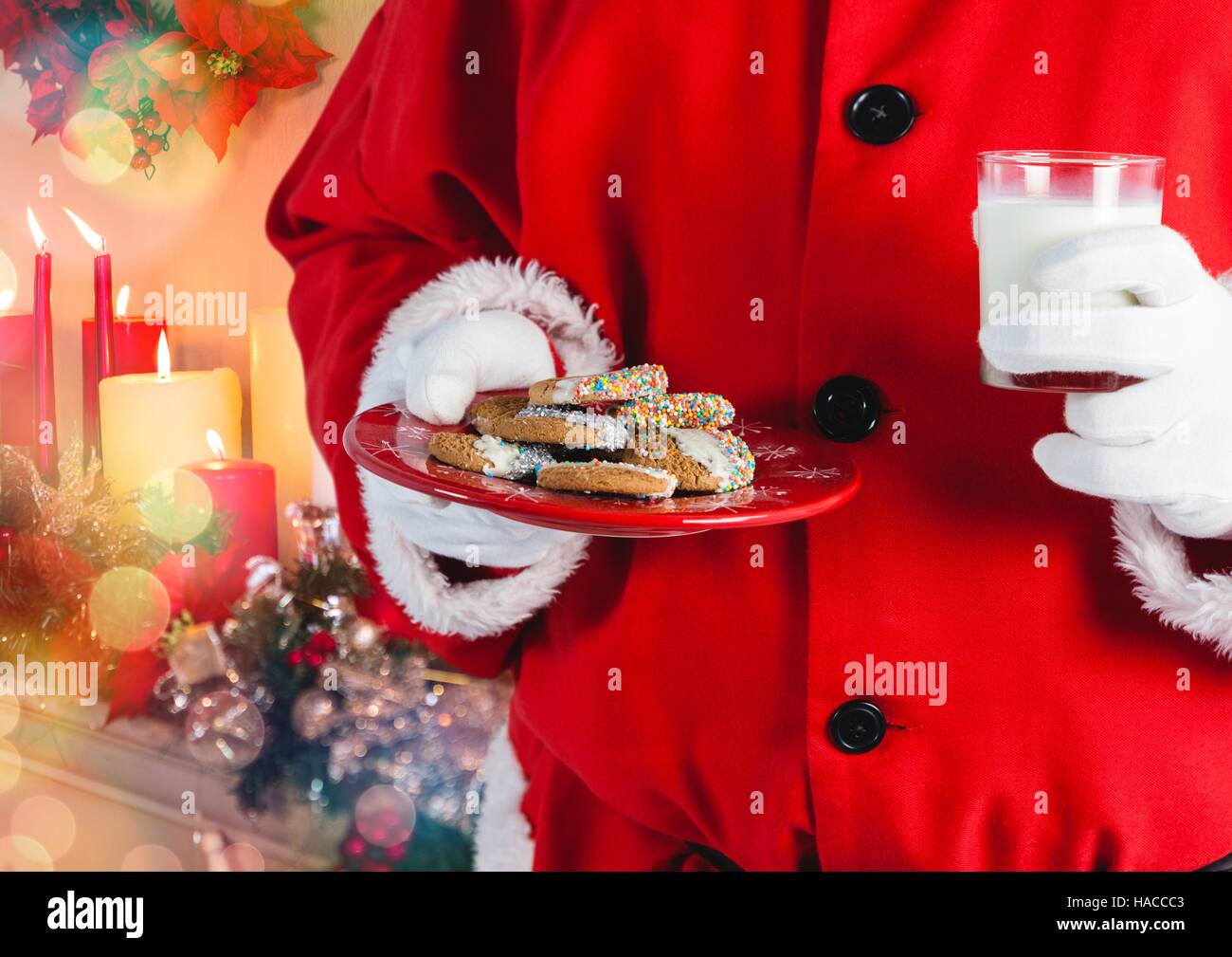 Santa hand holding cookies and a glass of milk Stock Photo - Alamy