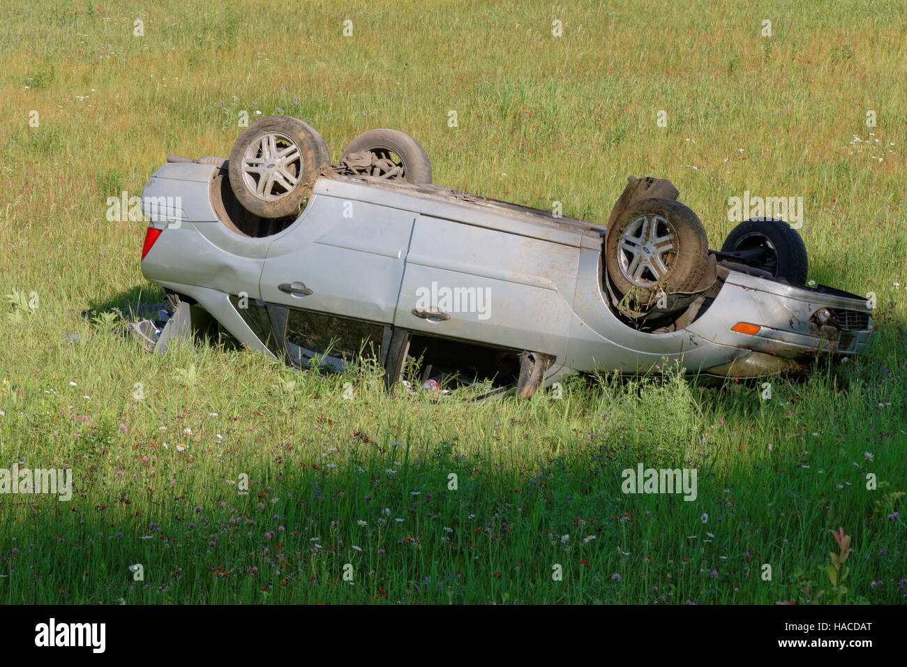 overturned car in field Stock Photo - Alamy