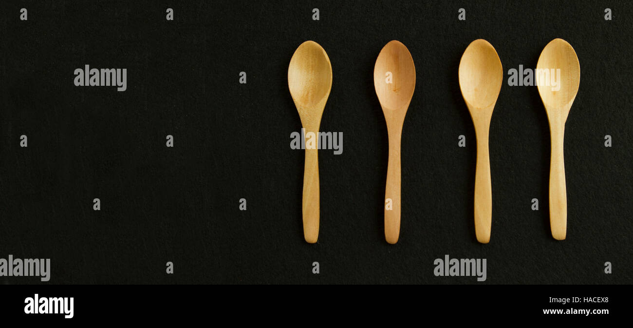 Four empty wooden spoons on the black background with copy space Stock ...