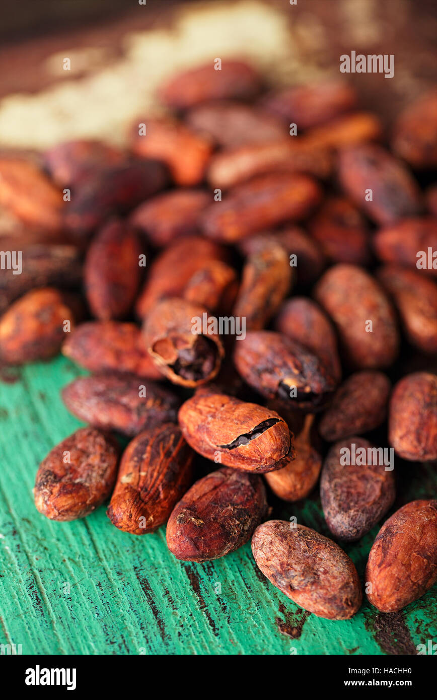 roasted cocoa chocolate beans on wood background macro Stock Photo - Alamy