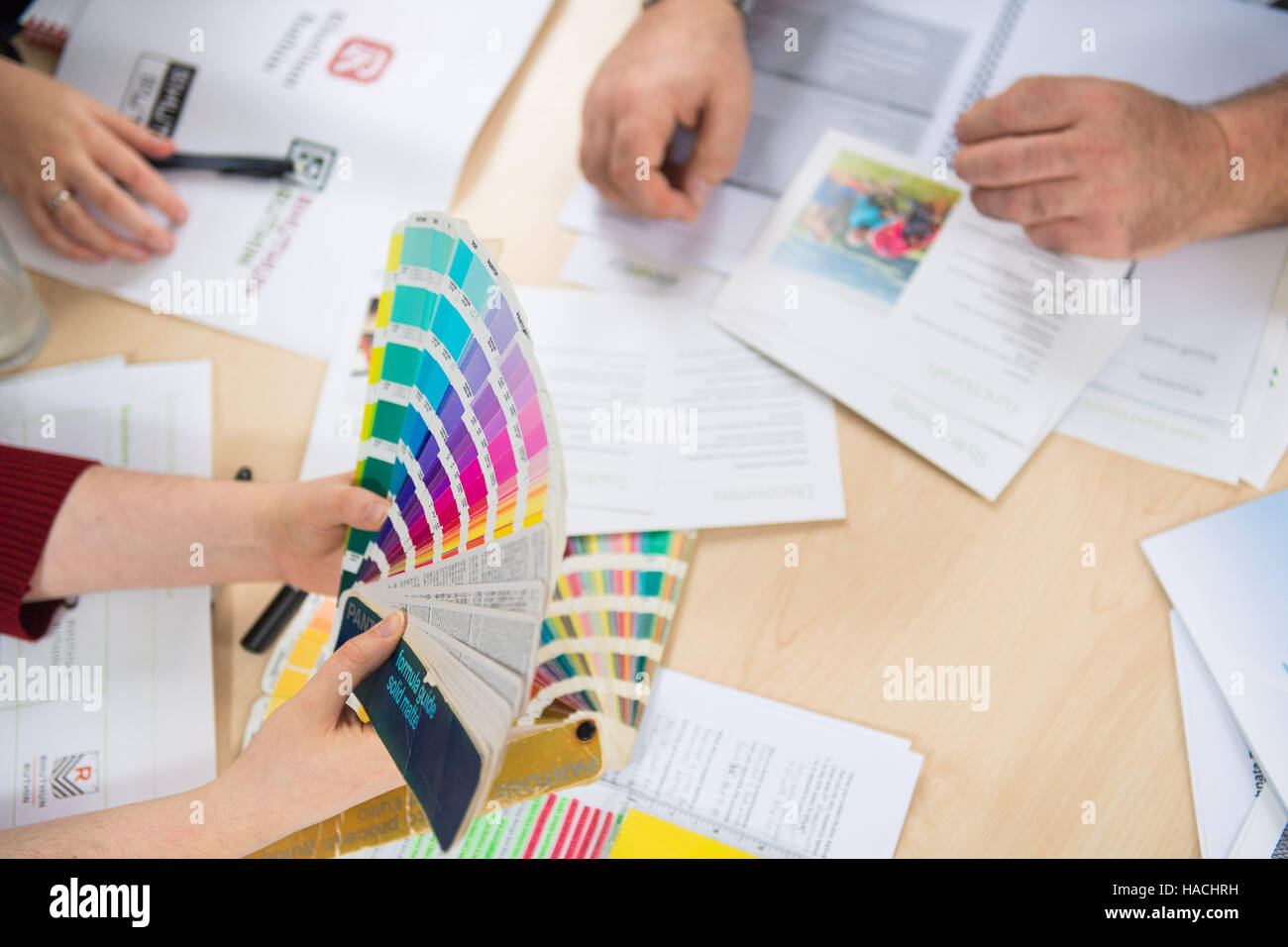 Graphic designers choosing from a Pantone colour fan deck Stock Photo ...