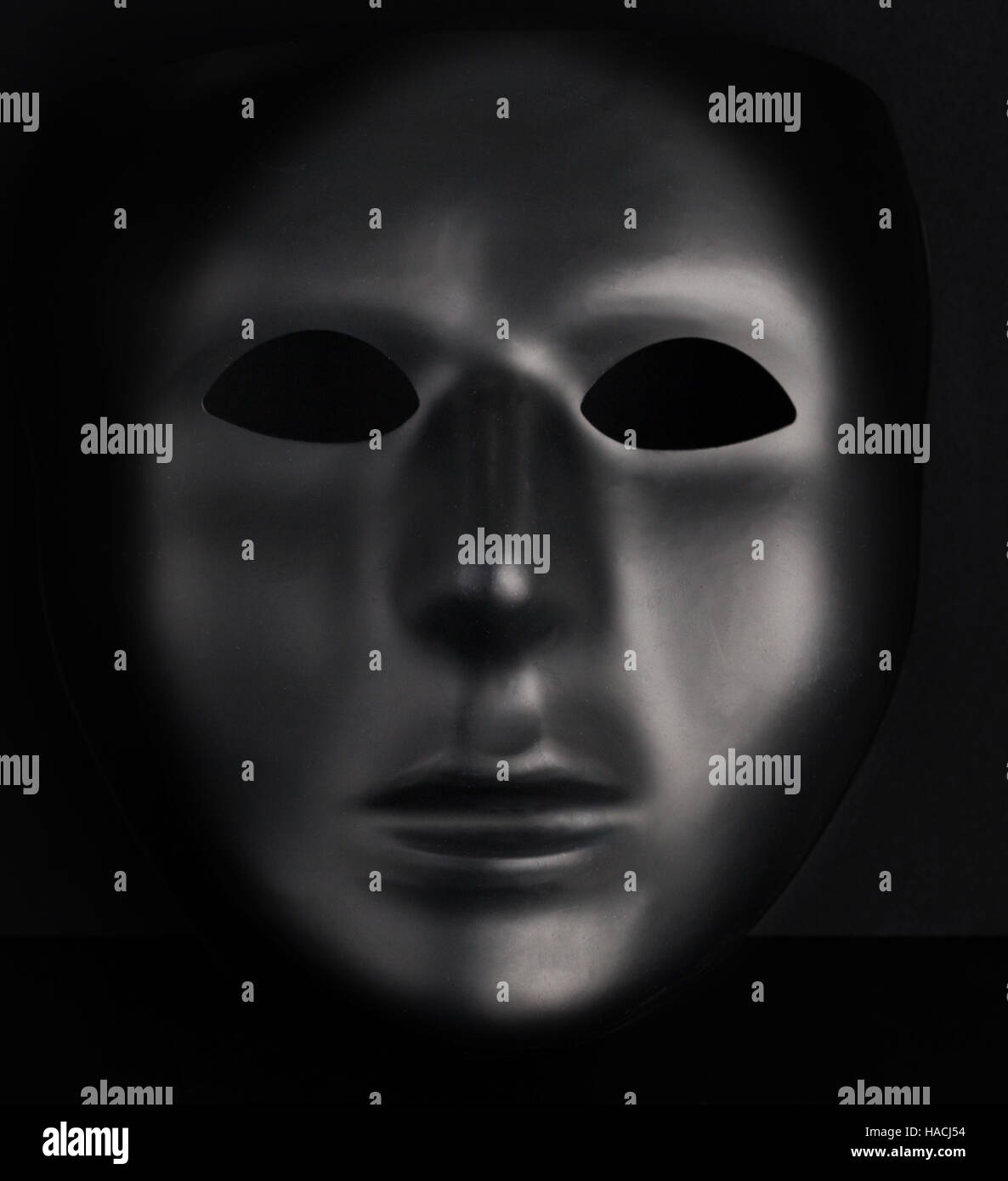 Anonymous black mask protruding from pitch black background. Anonymity ...