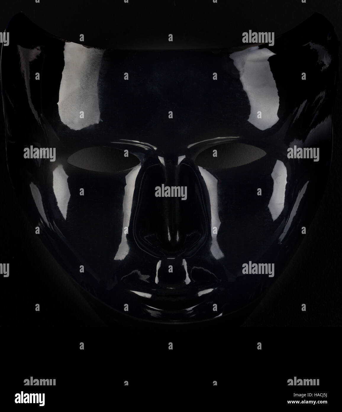 Shiny black mask silhouette on pitch black background Stock Photo - Alamy