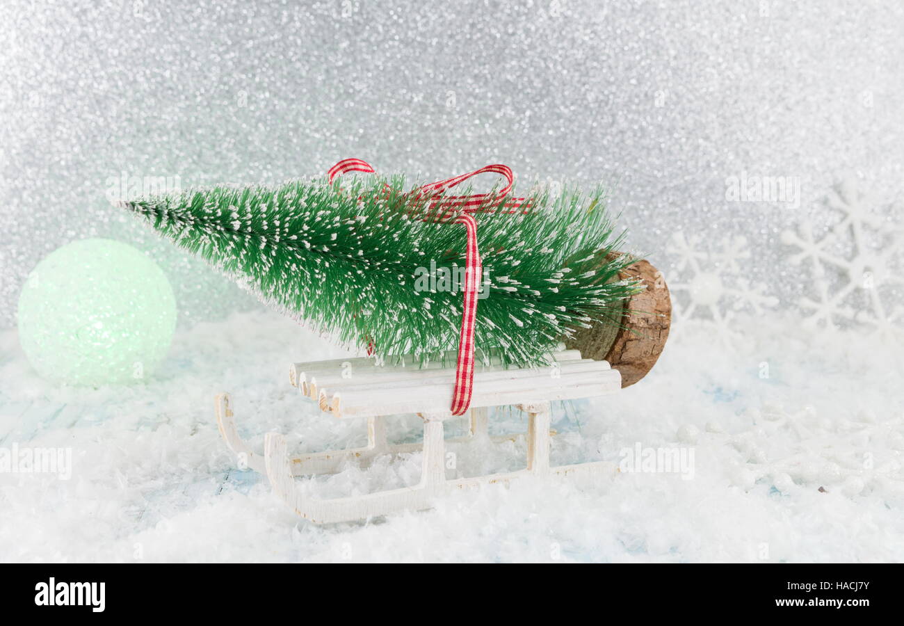 Small sleigh carrying a Christmas tree miniature Stock Photo - Alamy
