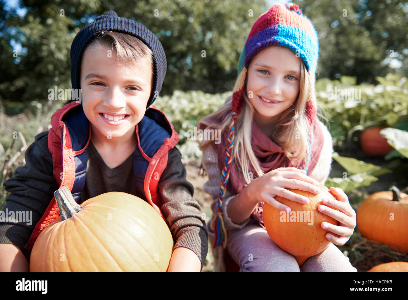 Boy and girl on pumpkin field Stock Photo - Alamy
