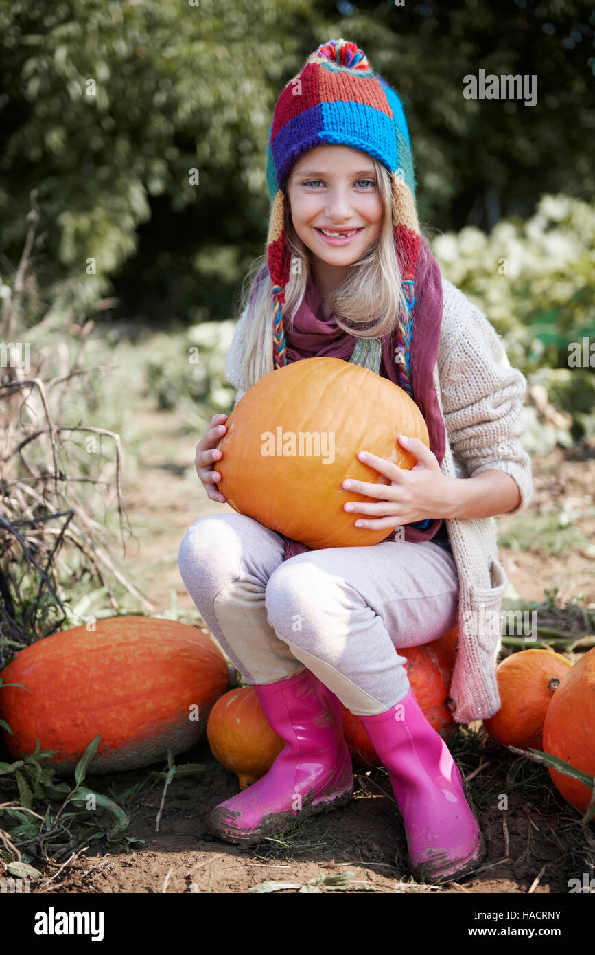 Blonde girl resting in the field full of pumpkins Stock Photo - Alamy