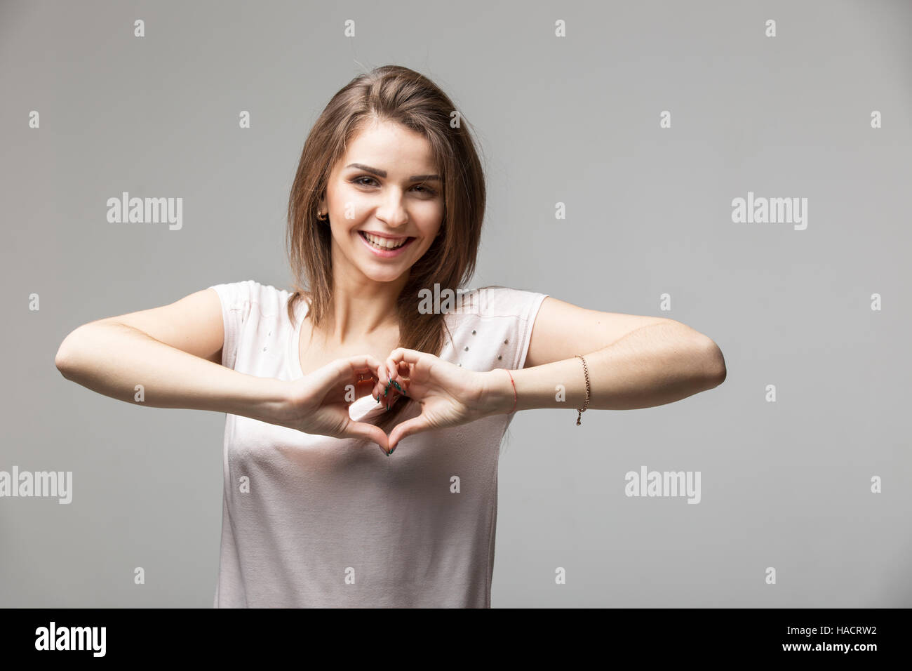 Beautiful woman making a heart symbol with her hands Stock Photo - Alamy