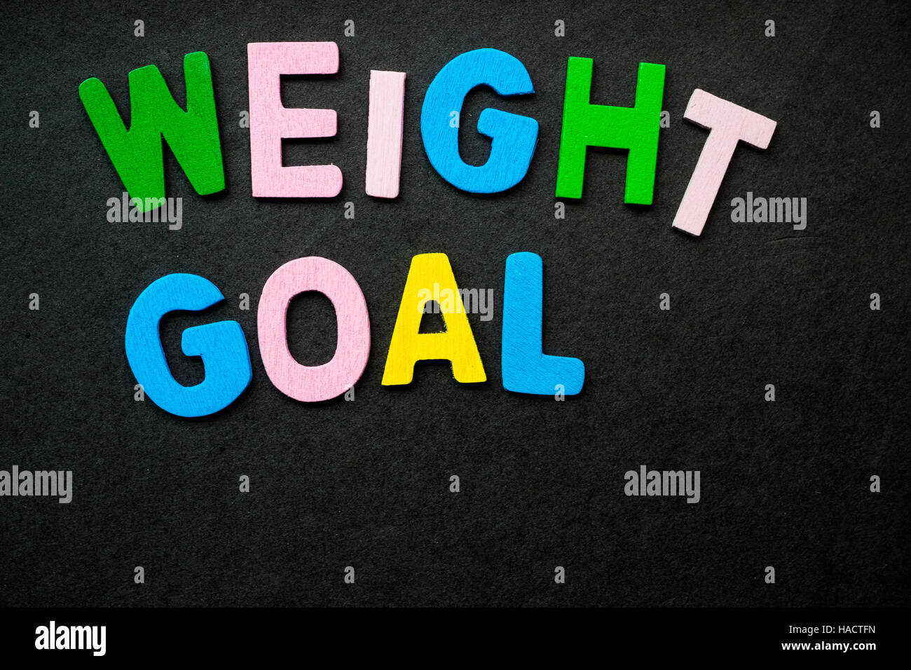 Colorful wooden letters forming the phrase "weight goal Stock Photo - Alamy