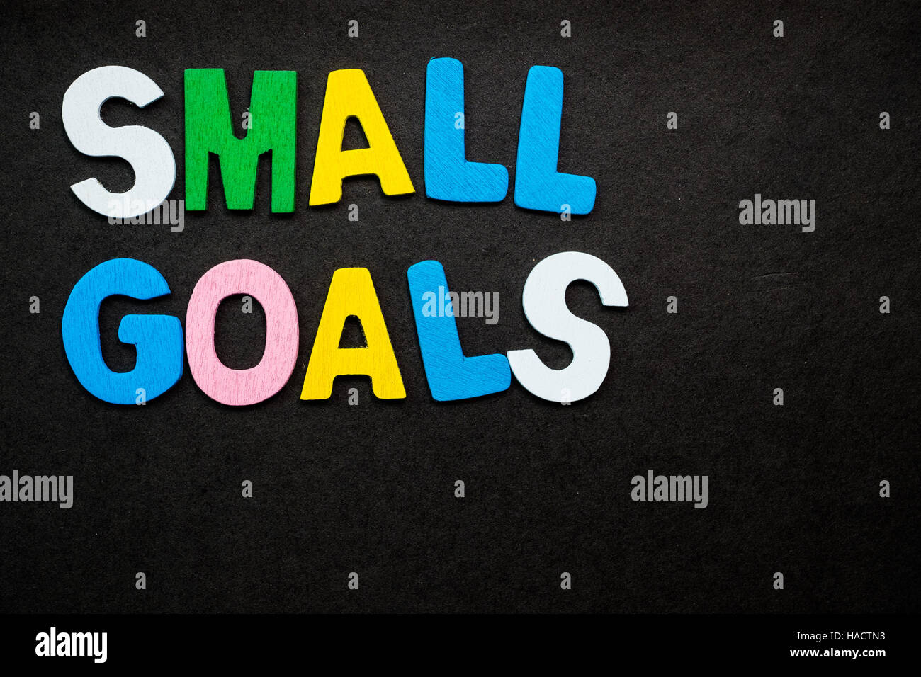 Colorful wooden letters forming the phrase "small goals Stock Photo - Alamy