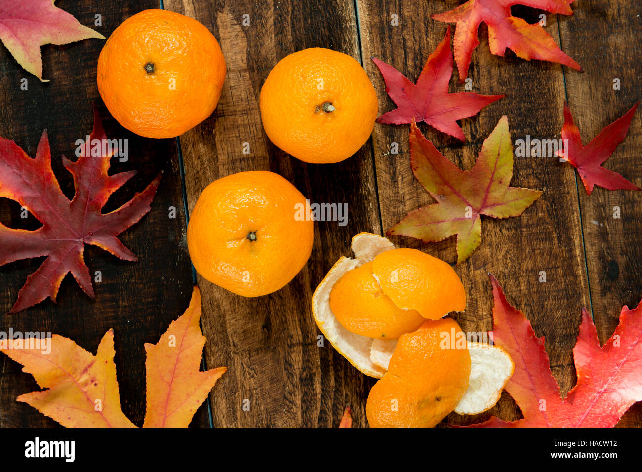 Three mandarins with autumn leaves, season´s fruit Stock Photo - Alamy