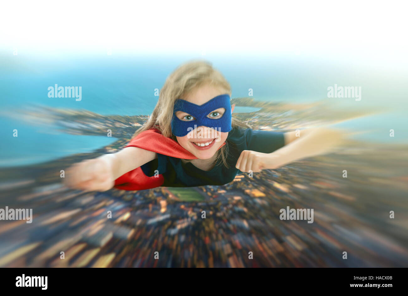 Superhero kid flying across the planet Stock Photo - Alamy