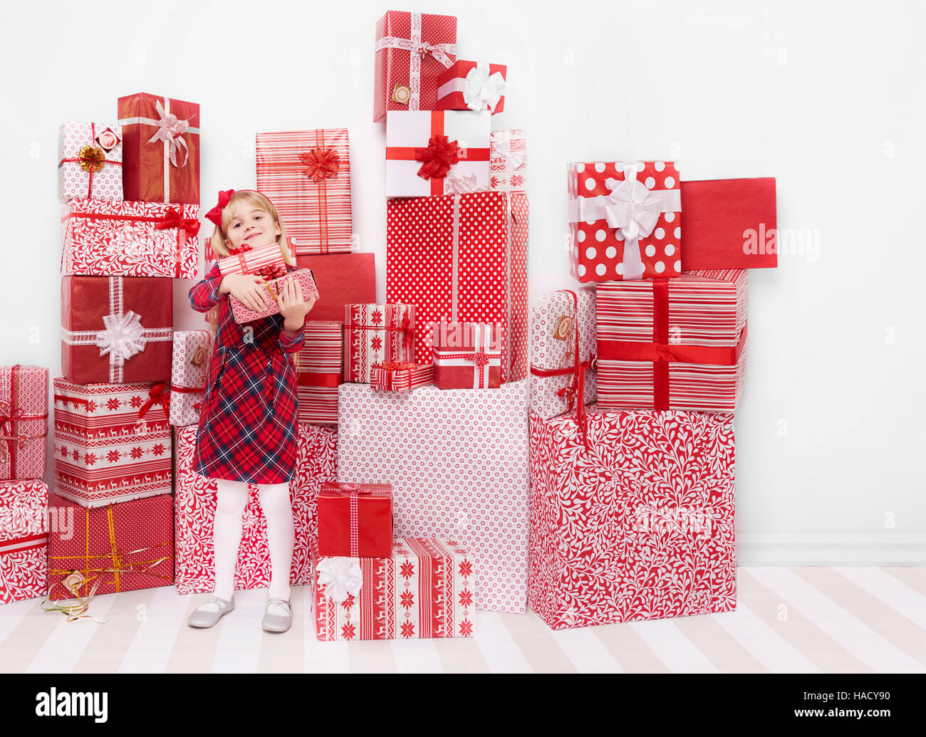 Little girl and wall of presents Stock Photo - Alamy