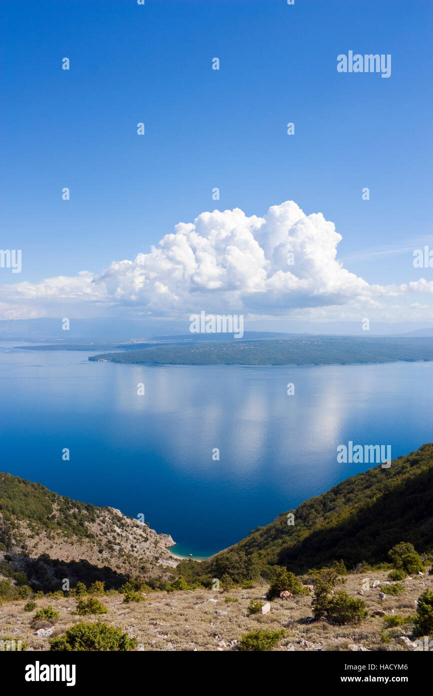 Small bay on croatia island cres, view to island krk with some clouds ...