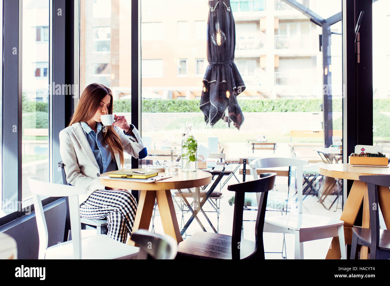 Beautiful Young Woman Drinking Coffee in Coffee Shop Stock Photo - Alamy
