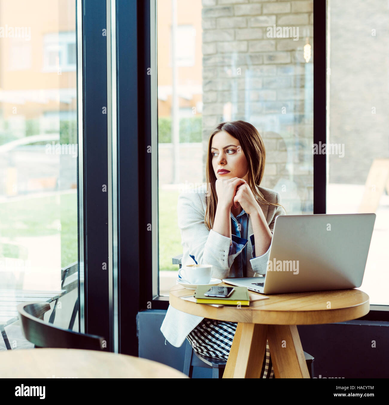 Beautiful Young Woman Sitting in Coffee Shop and Looking Out the Window ...