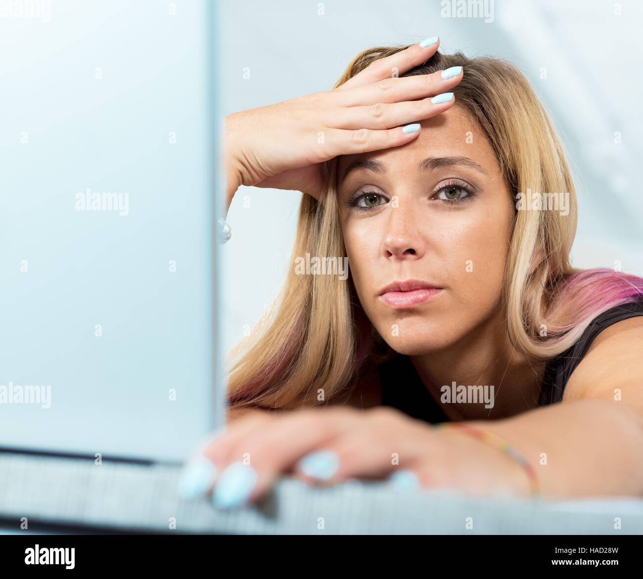 tired woman with her hand on her brow as she read something on her ...
