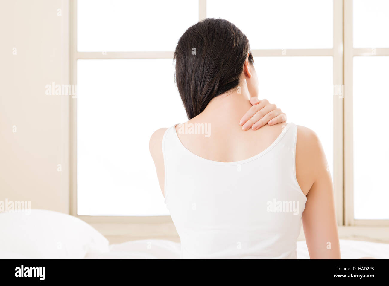 Beautiful asian woman suffering Shoulder neck ache tired sit on bed ...