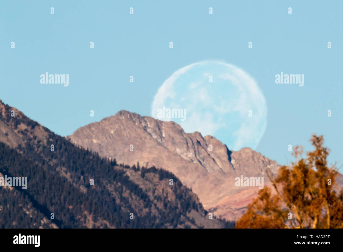 Full super moon setting at sunrise over Rocky Mountains, Salida ...