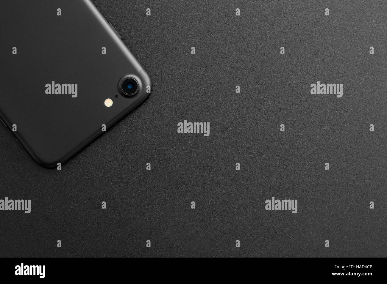 Black phone showing backside view on black background Stock Photo - Alamy