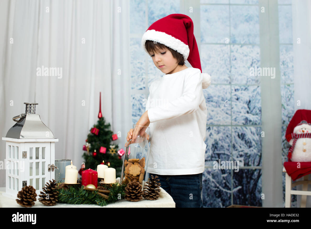 Christmas portrait of cute little preschool boy, eating cookies and ...