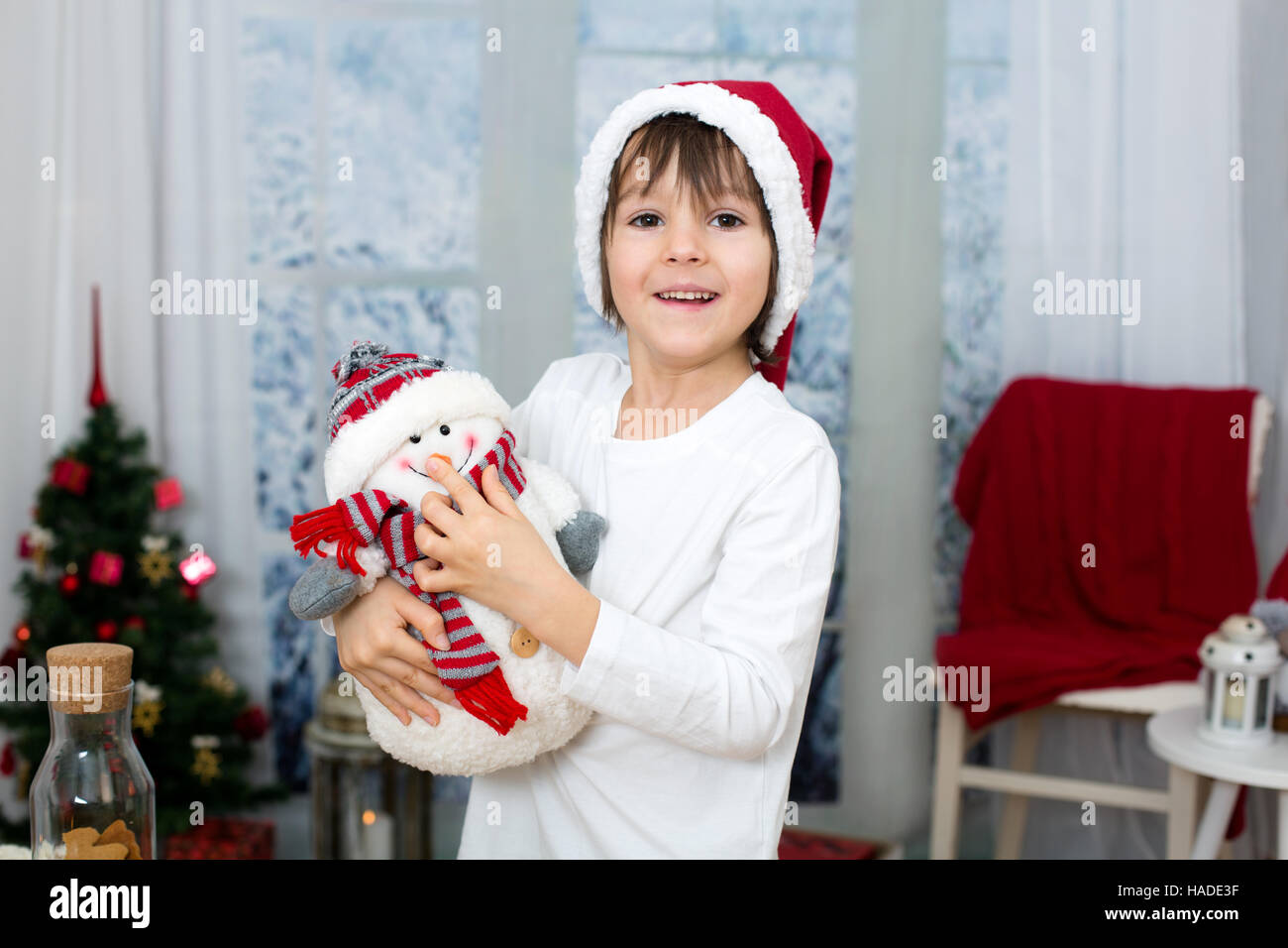 Christmas portrait of cute little preschool boy, eating cookies and ...
