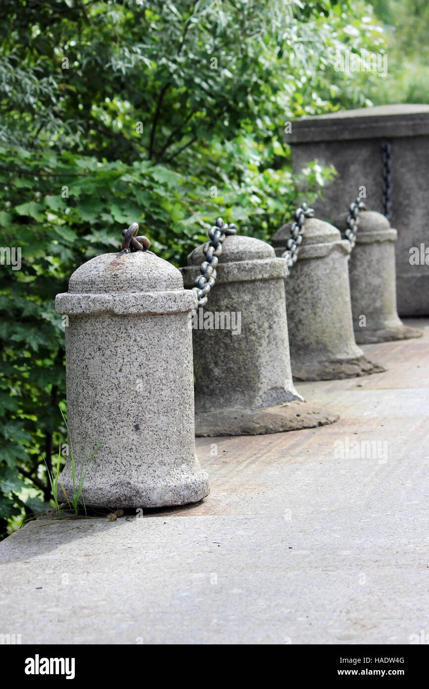 historic concrete pillars with metal chains as a guard at the road ...
