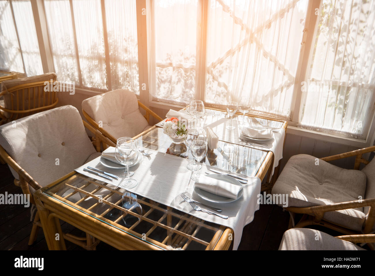 Table with plates and glasses. Chairs beside windows. Invite neighbours ...