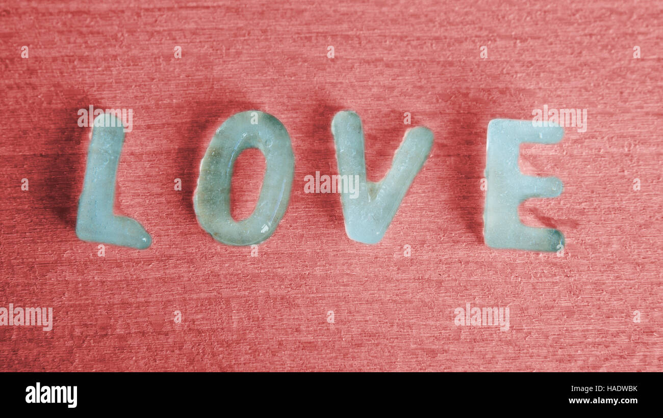 ice cubes as the word Love on red background Stock Photo - Alamy