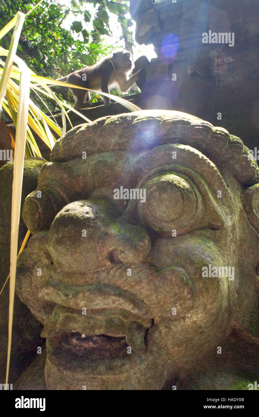 Monkeys having fun on stone statues of Hindu Holy Monkey Forest. Ubud ...