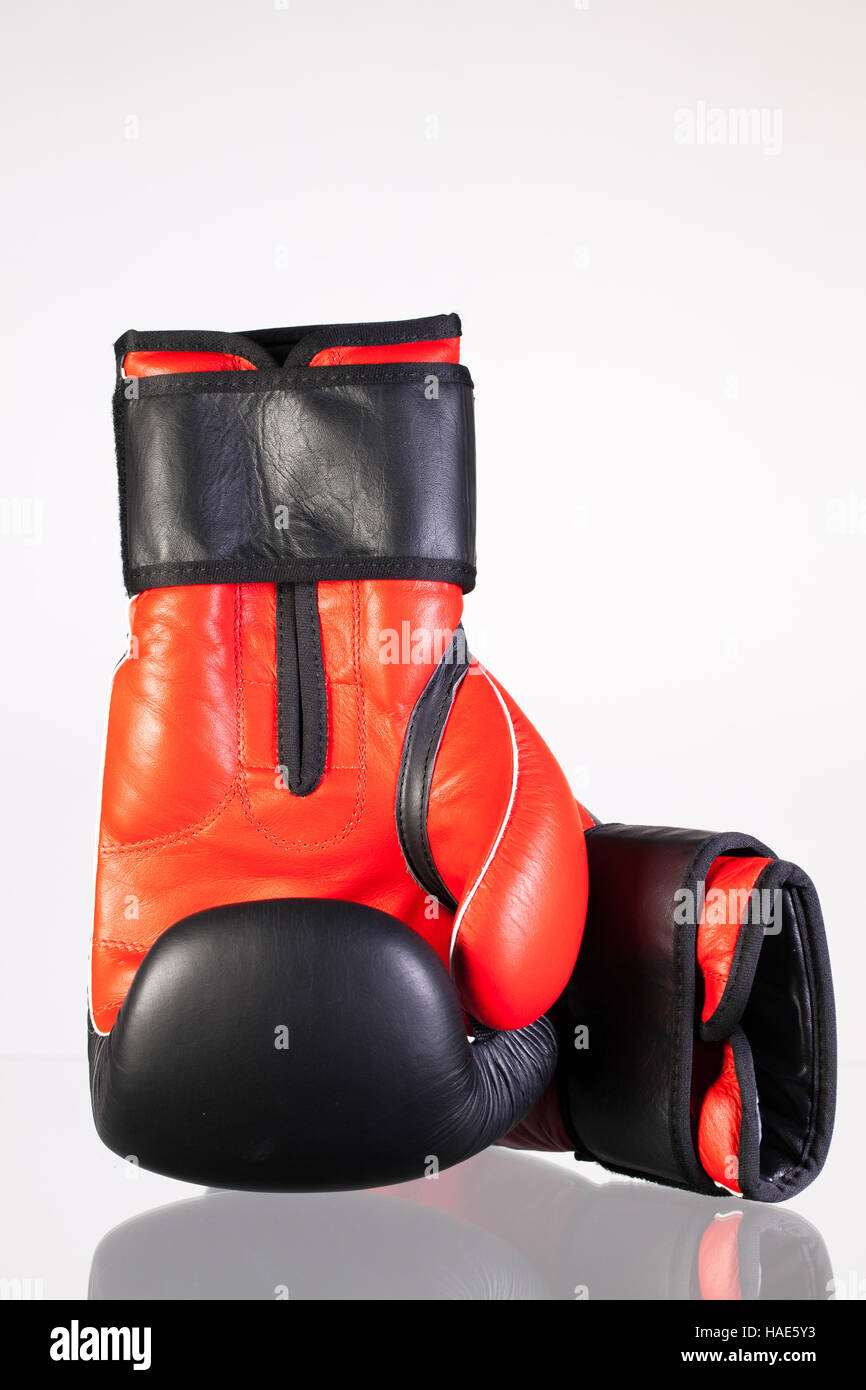 Red and black boxing gloves on a glass table isolated on white ...
