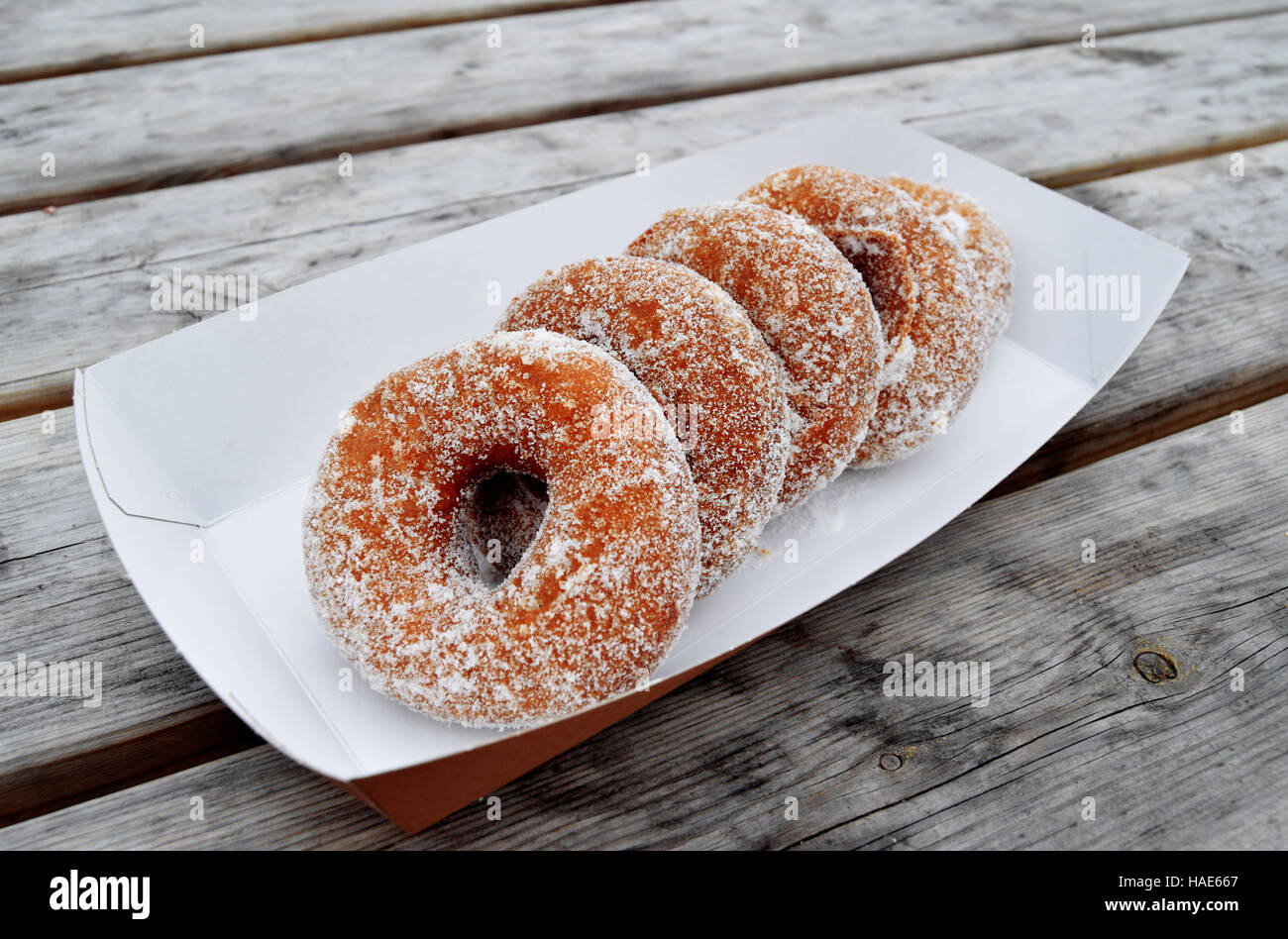 Five tasty donuts in the carton box on the wood table Stock Photo - Alamy