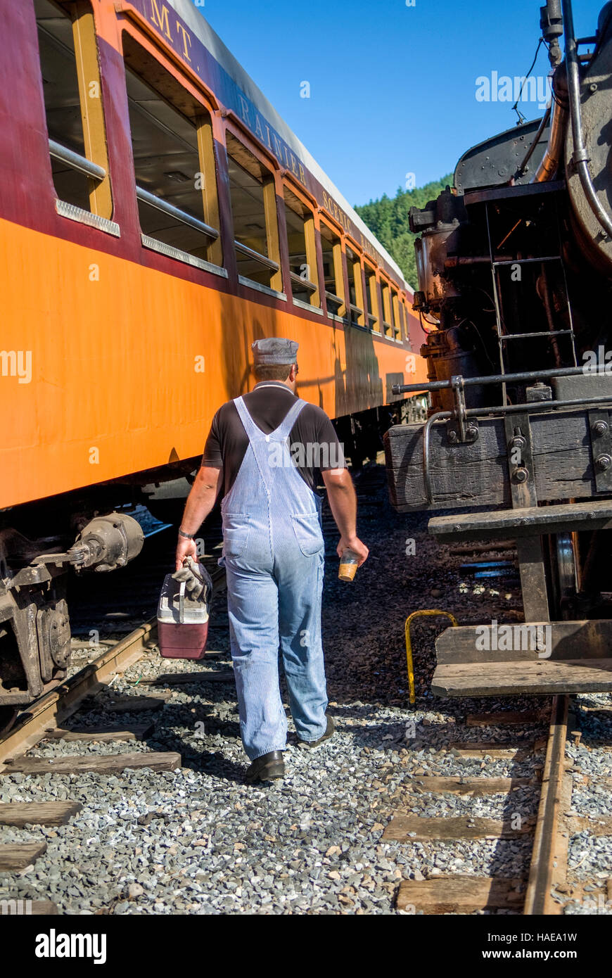 classic old trains on track with worker going to work repairing steam ...
