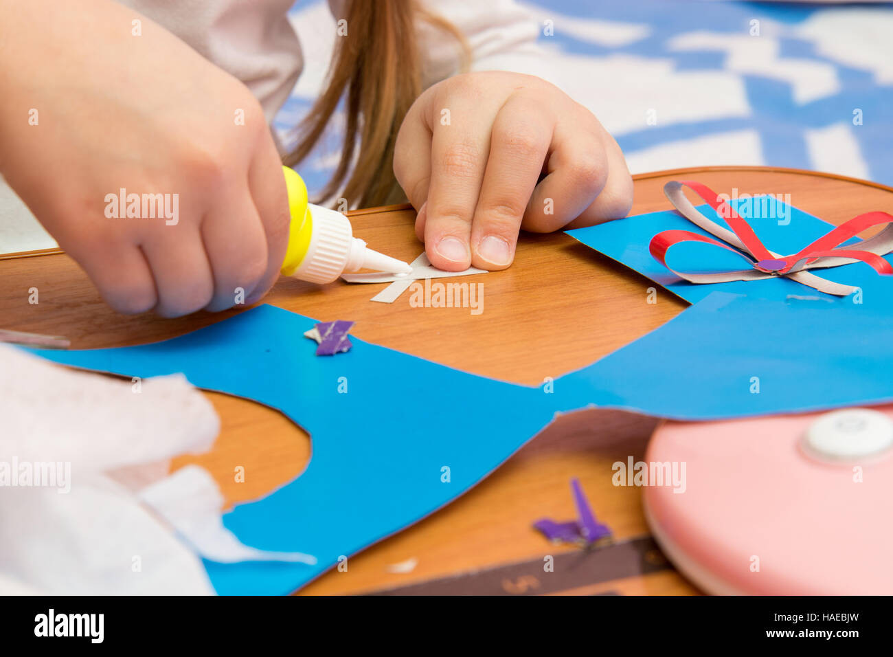Girl sticks two strips, making crafts out of colored paper Stock Photo ...