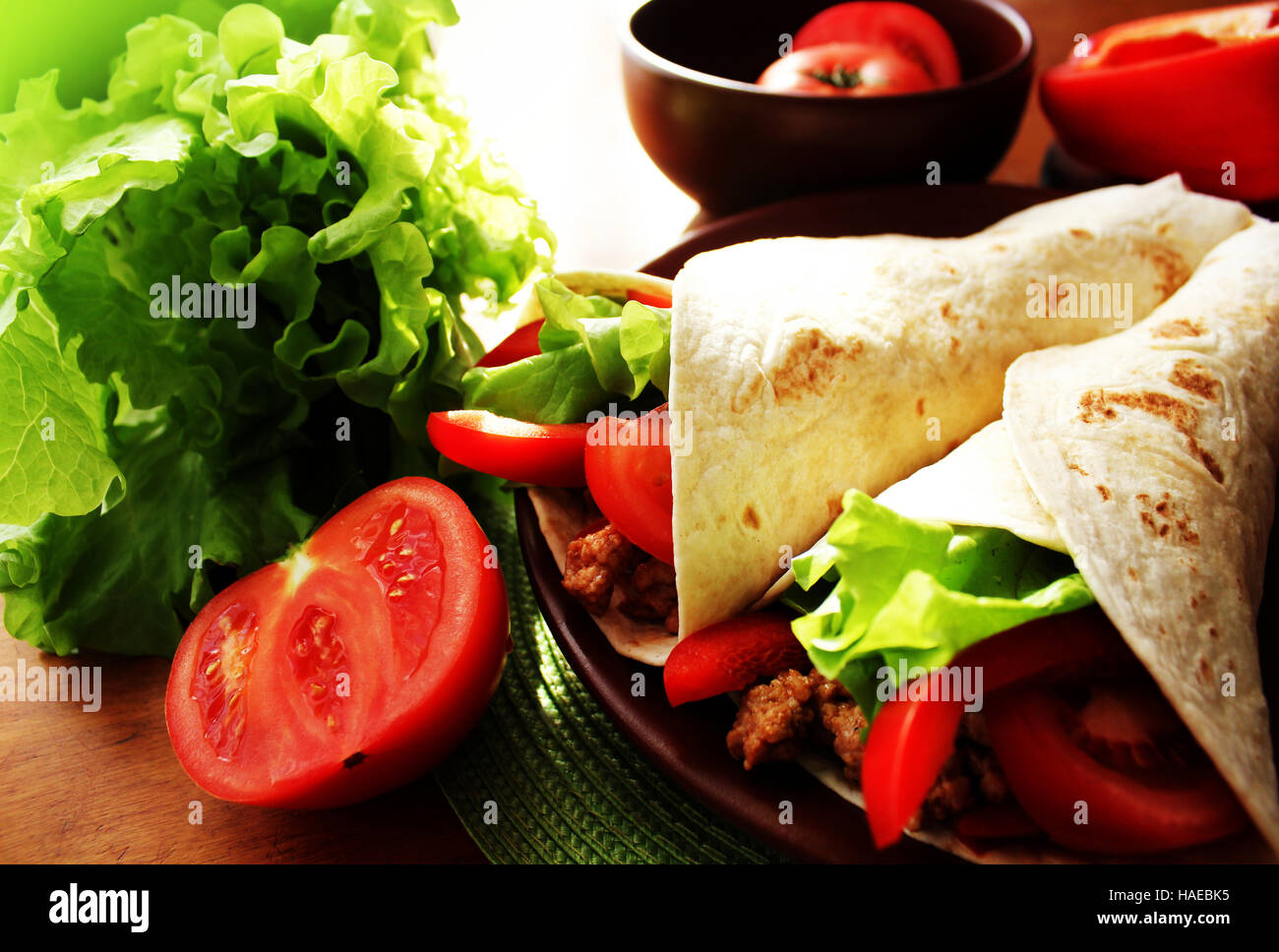 burrito with meat and ingredients on wooden table Stock Photo - Alamy
