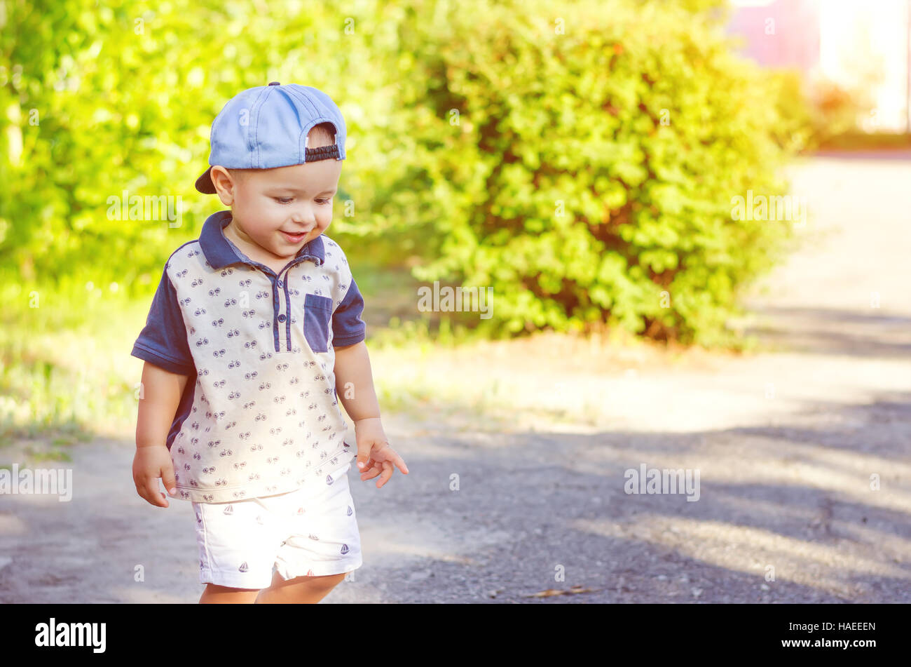 little boy wearing a cap during outdoor movement. Walk in nature with ...