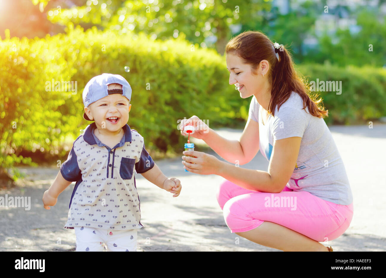Running little boy wearing cap outdoors. Walk in nature with my mother ...