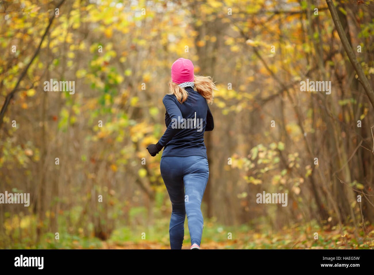 Slender girl running in park in autumn Stock Photo - Alamy