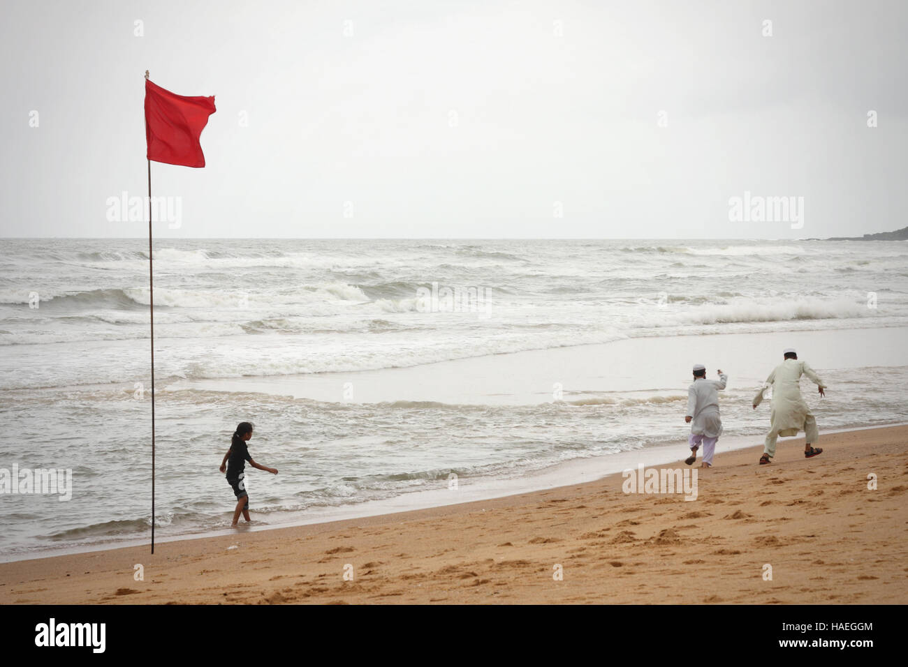 People playing near rough sea, Goa, India Stock Photo - Alamy