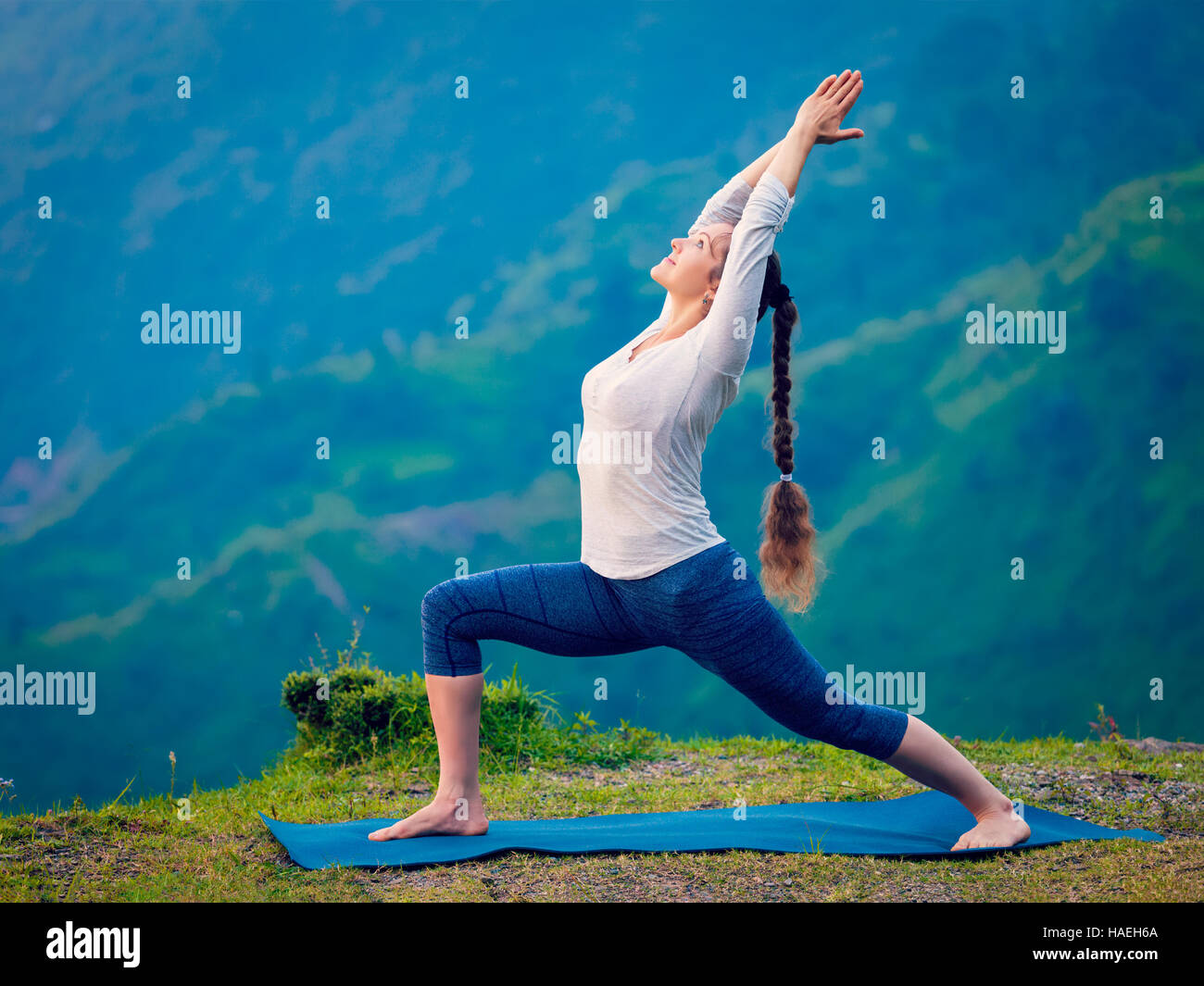 Woman doing yoga asana Virabhadrasana 1 - Warrior pose outdoors Stock ...