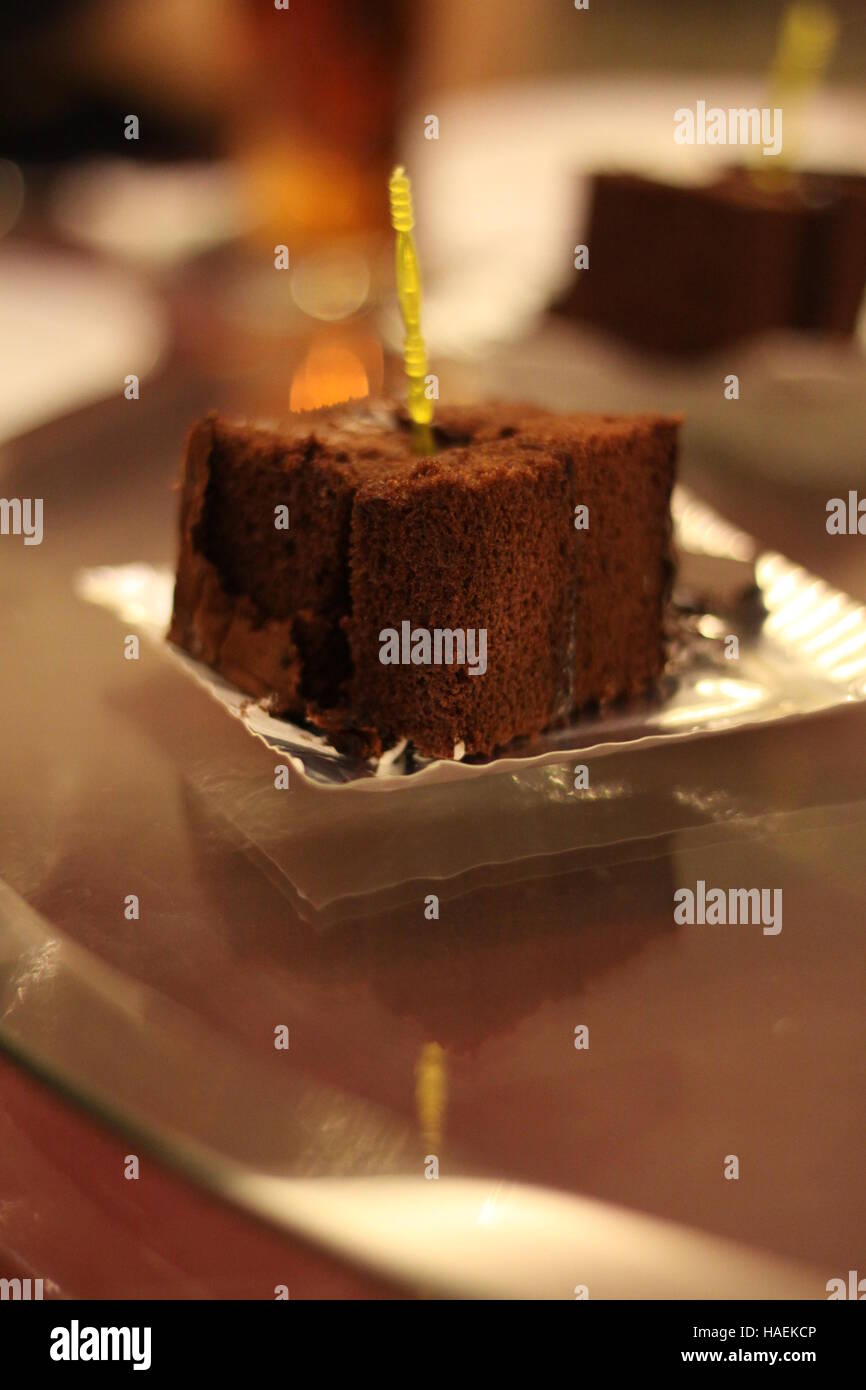 piece of birthday chocolate cake with toothpick Stock Photo - Alamy
