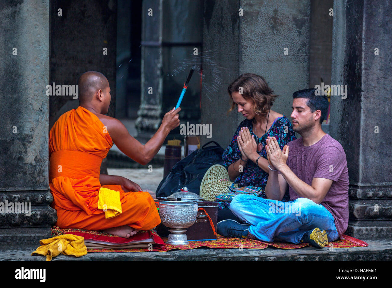 A western couple receive a blessing from a Buddhist monk at Angkor Wat ...