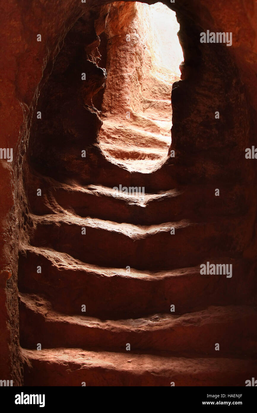 Sun peeks through dim rock staircase passageway in ancient orthodox ...