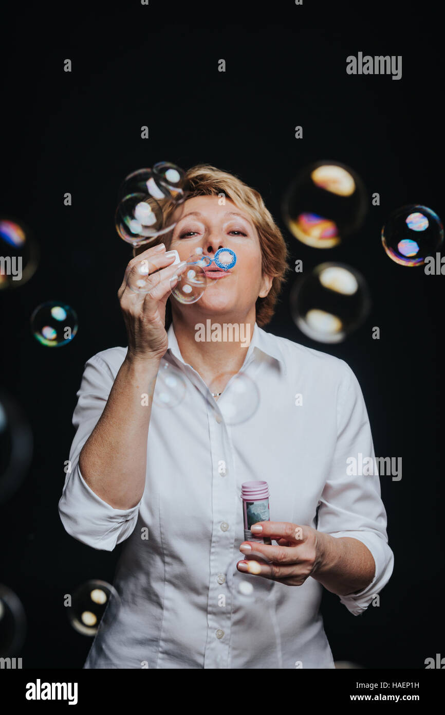 Middle aged woman blowing soap bubbles Stock Photo - Alamy