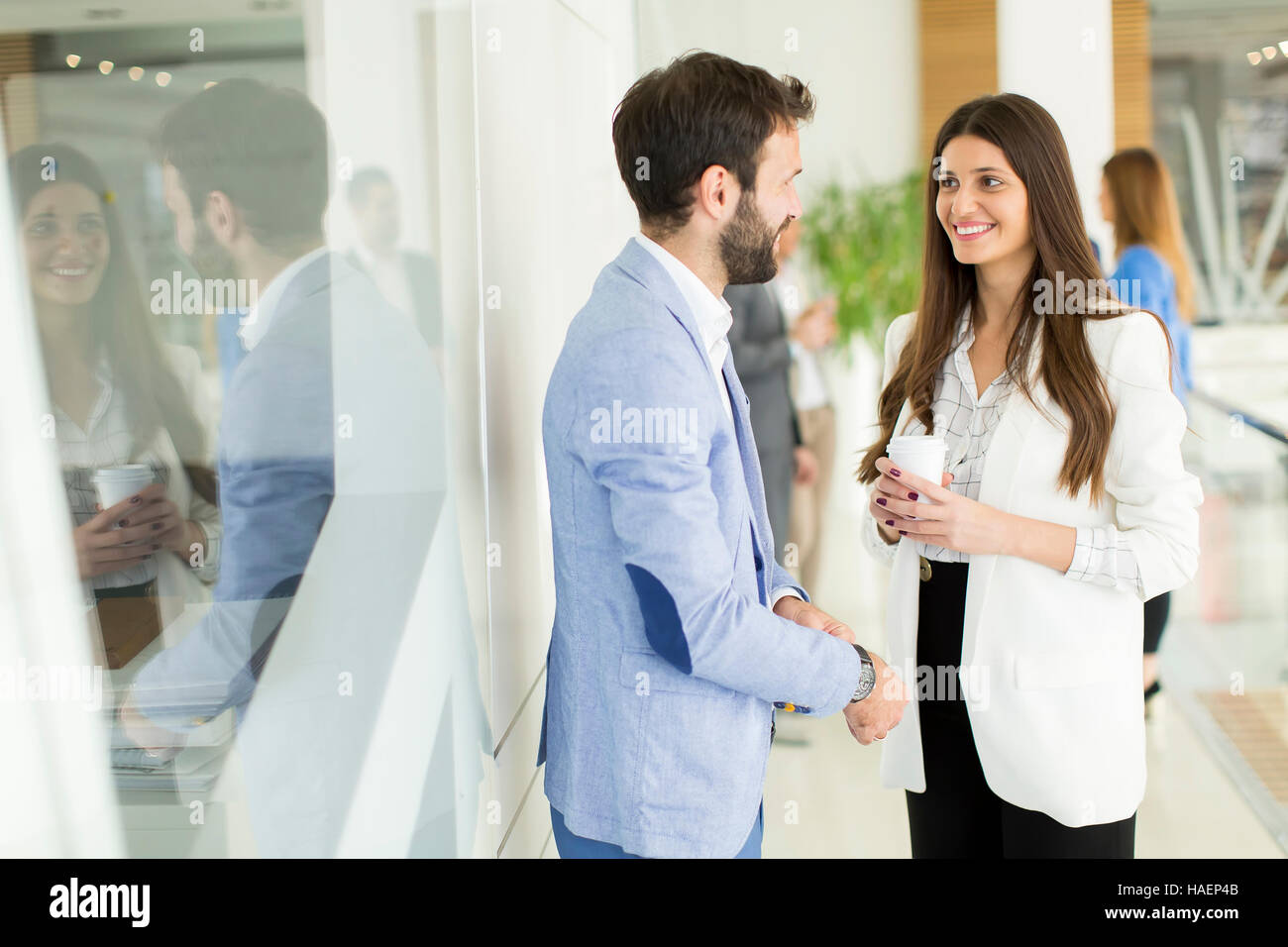 Business partners talking while businesswoman drinking coffee and young ...