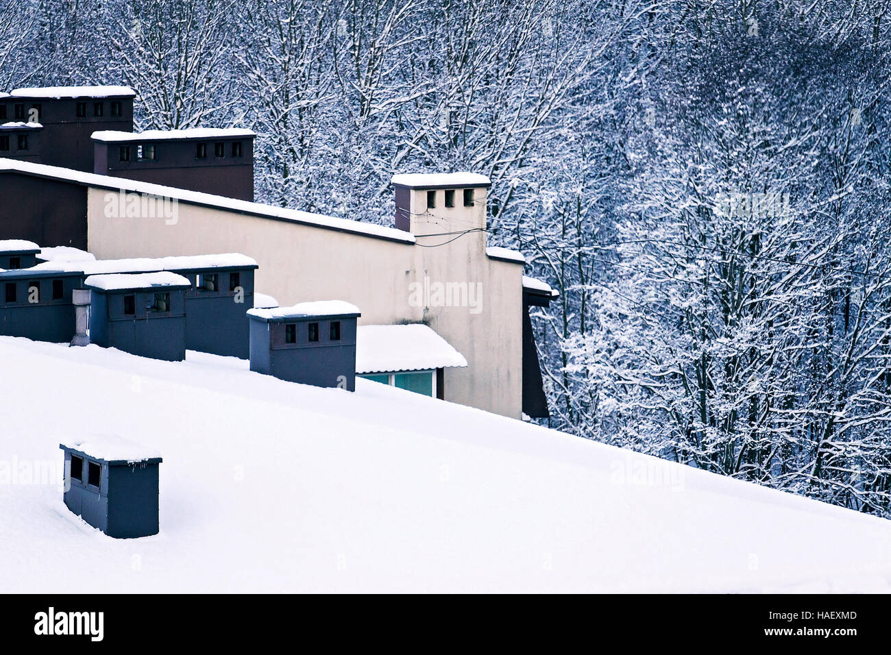 Winter view from above. Apartment building roof with chimneys covered ...